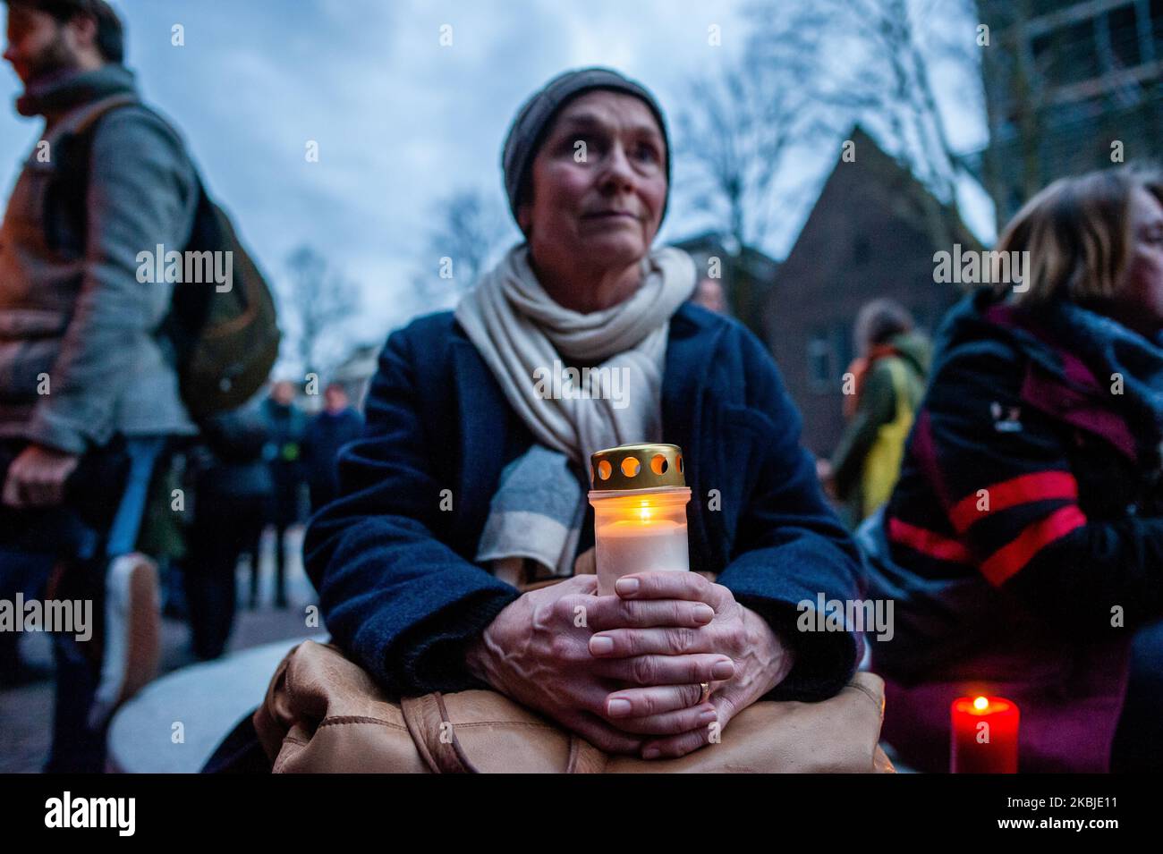 A woman is holding a candle before the demonstration Stop the refugee ...