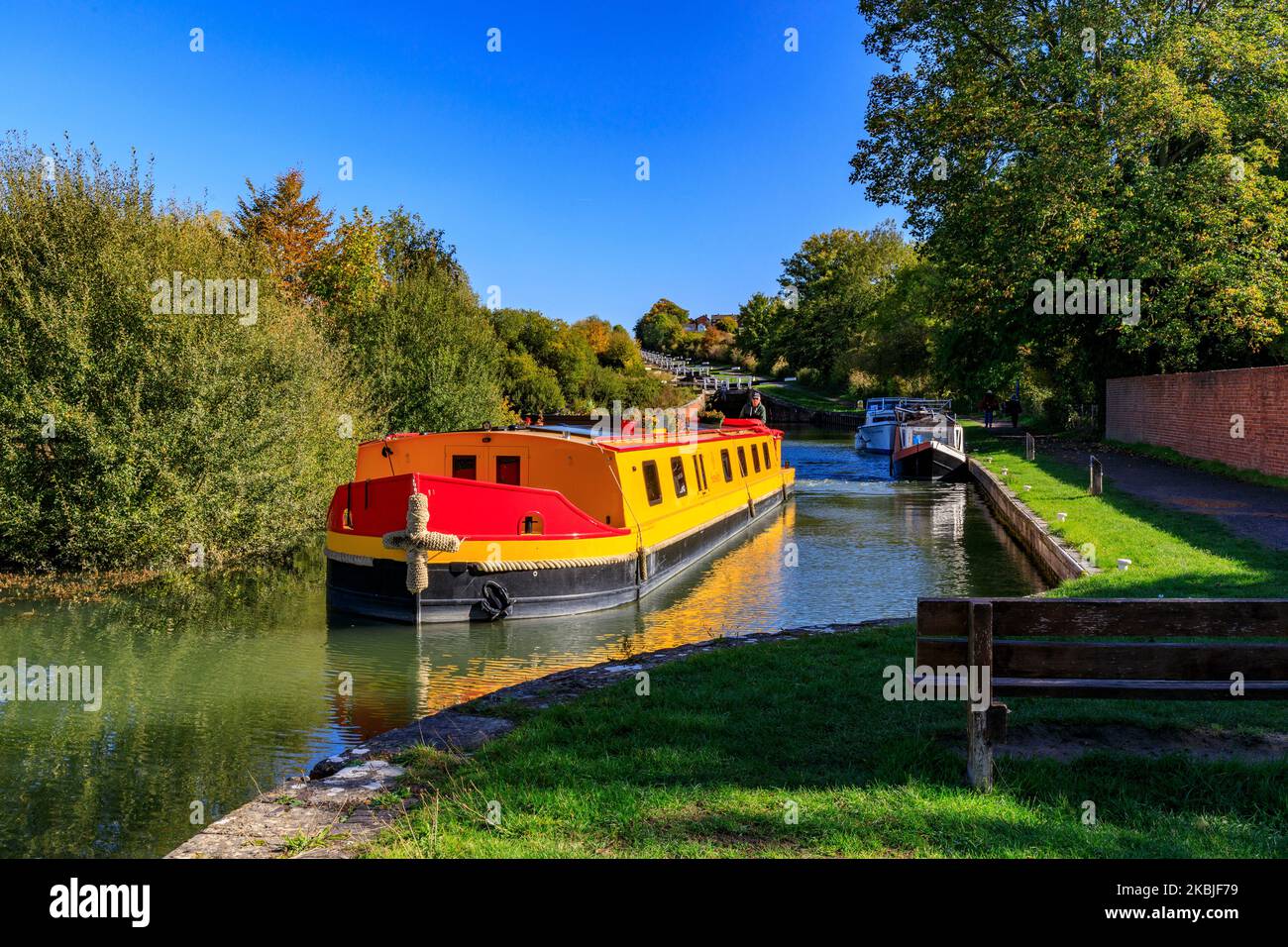 A colourful wide beam canal boat between two of the 29 locks at Caen ...