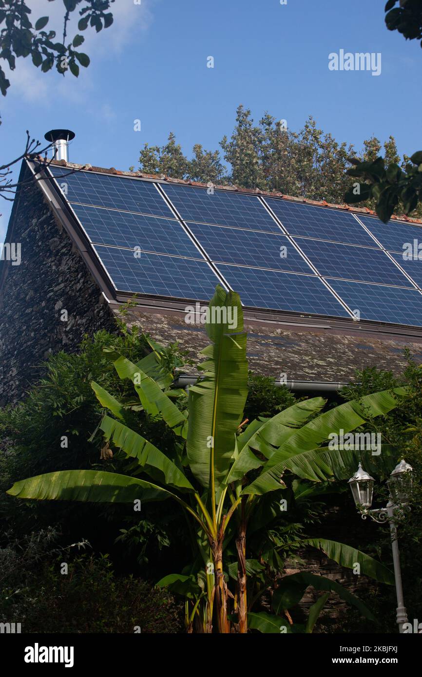 Solar panels produce electricity. A chimney outlet crowns the roof ...