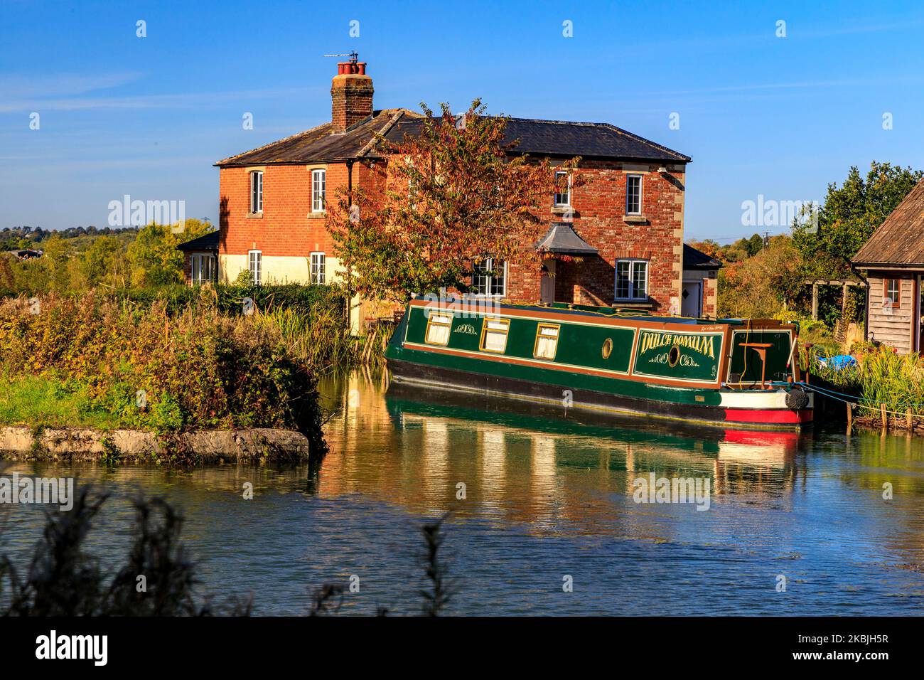 A narrowboat moored in front of a red bricked house at Caen Hill on the ...