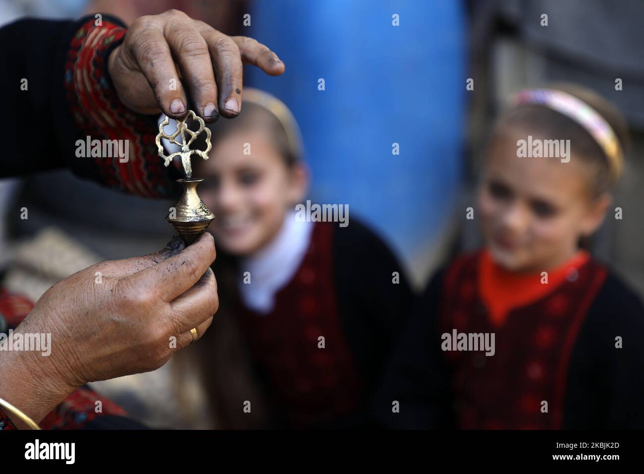 Palestinian Hadya Qudeih fills a brass container with traditional kohl ...
