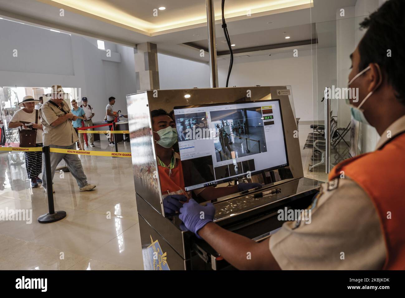 Port health officer observes cruise passenger's body temperature using ...