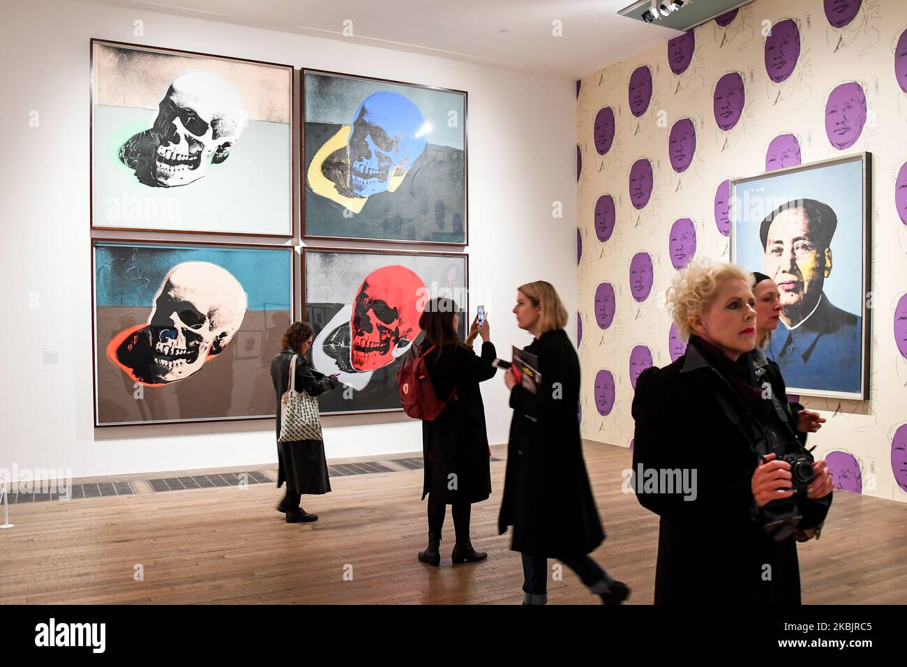 Visitors and gallery assistants look at artworks entitled "Mao" 1972 ...