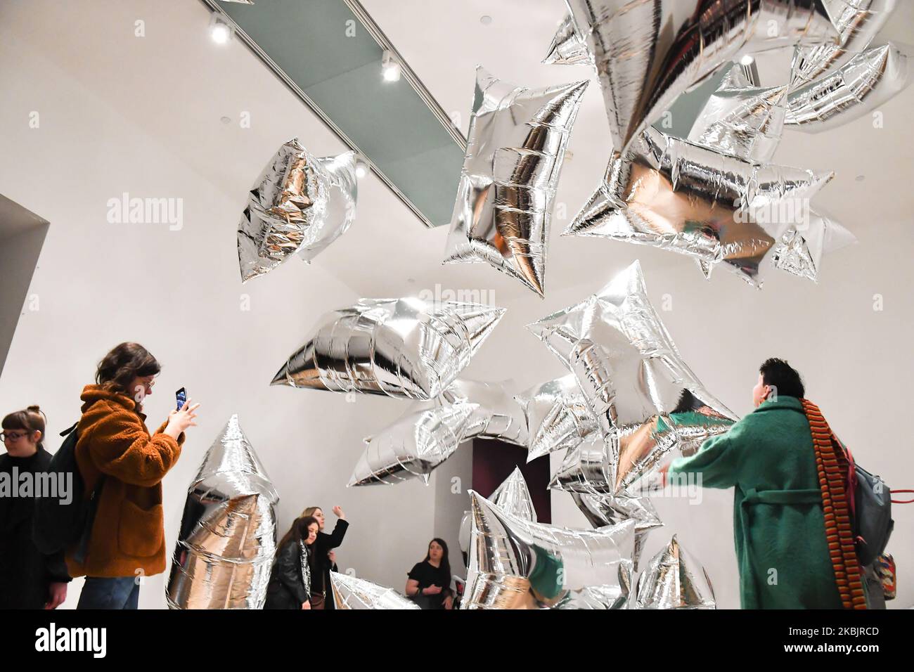 Visitors and gallery assistants interact with an installation entiteld ...