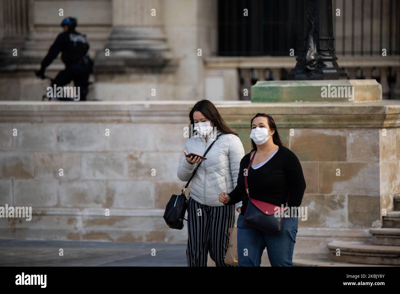 Tourists wearing face mask near the pyramide of the louvre museum in ...