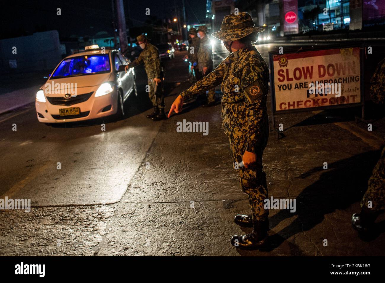 Police officers monitor the entry and exit of vehicles along a major ...