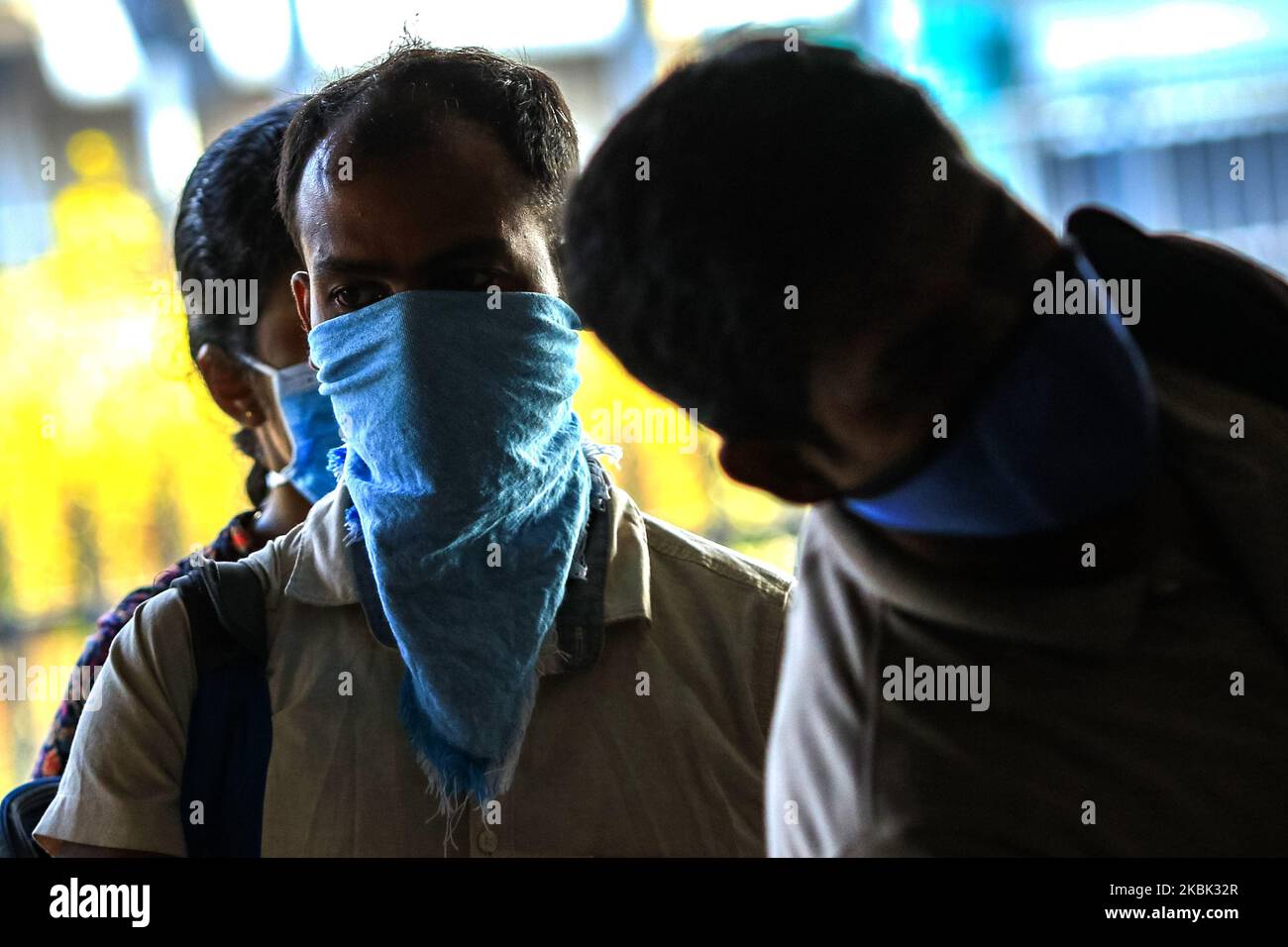 Sri Lankans wearing protective masks arrive at the main railway station ...