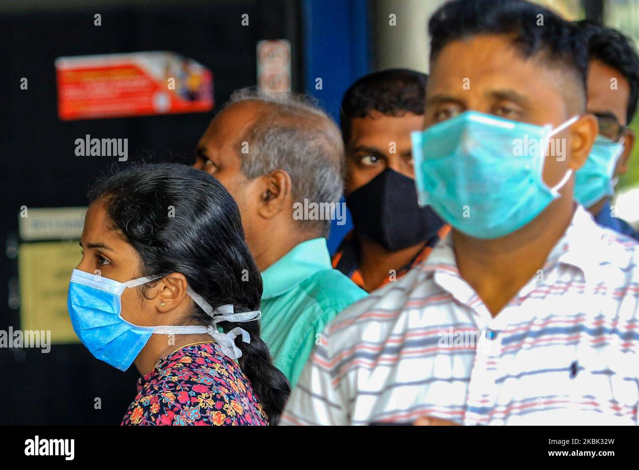 Sri Lankans wearing protective masks arrive at the main railway station ...