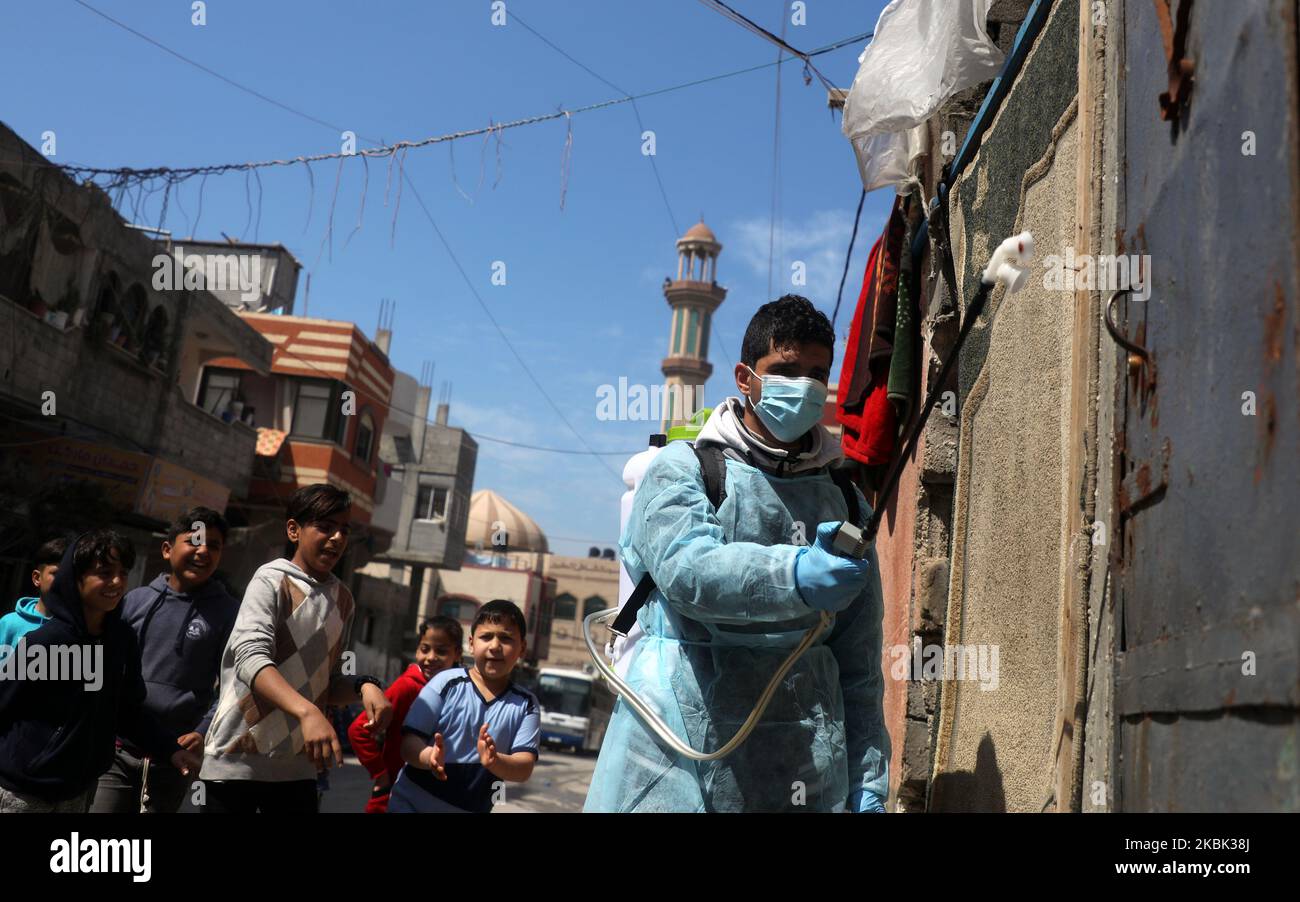 Palestinian volunteers sprays disinfectant a street at al-Shati refugee ...