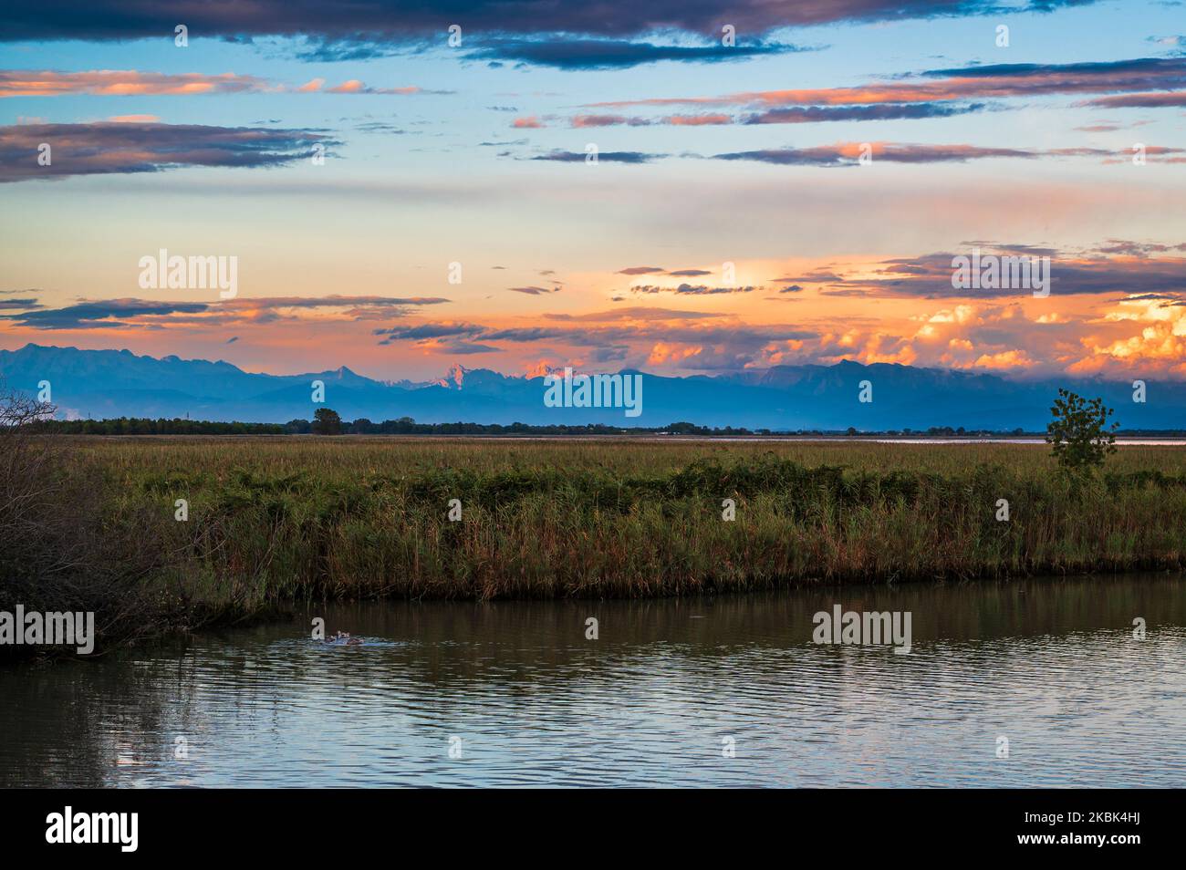 Towards the sunset. Marano lagoon late summer colors. Clouds and sun ...