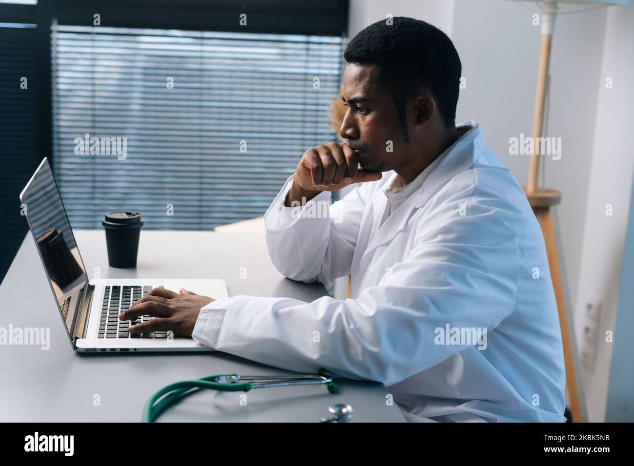 Side view of confused black male doctor wearing white coat uniform ...