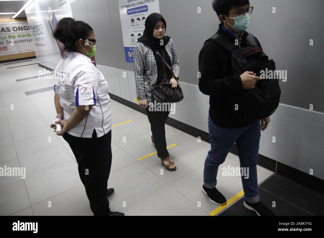 People keep one meter apart while waiting in line to entering MRT ...