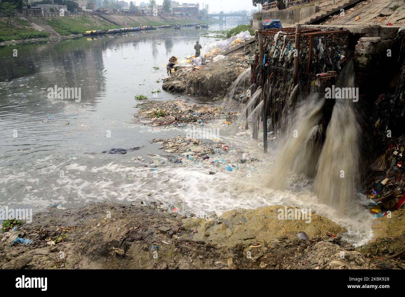 Waste water flows from the city drain into the Turag River in Dhaka ...