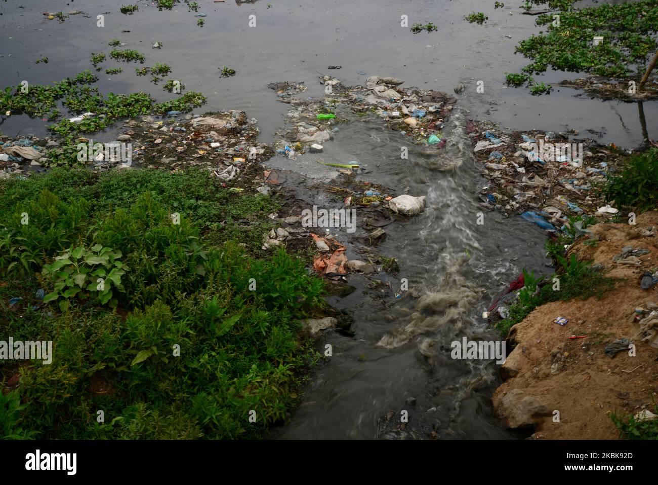Waste water flows from the city drain into the Turag River in Dhaka ...
