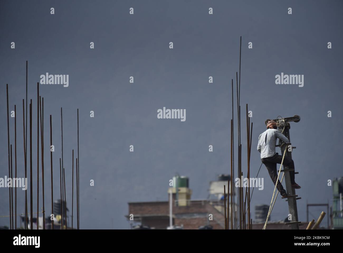 A migrant worker from India, Bihar installing Concrete Lift Machine for ...