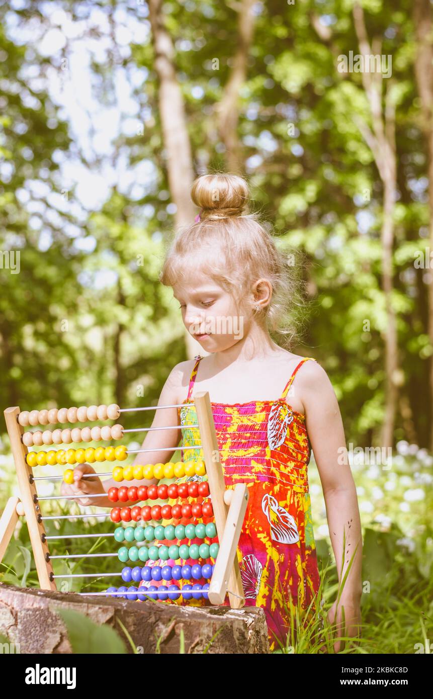adorable blond girl learning maths in abacus in the spring forest Stock ...