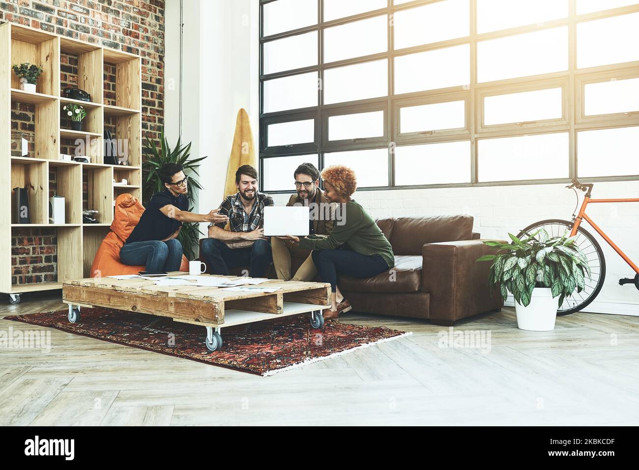 Using the best tools to do the job. a group of designers using a laptop ...