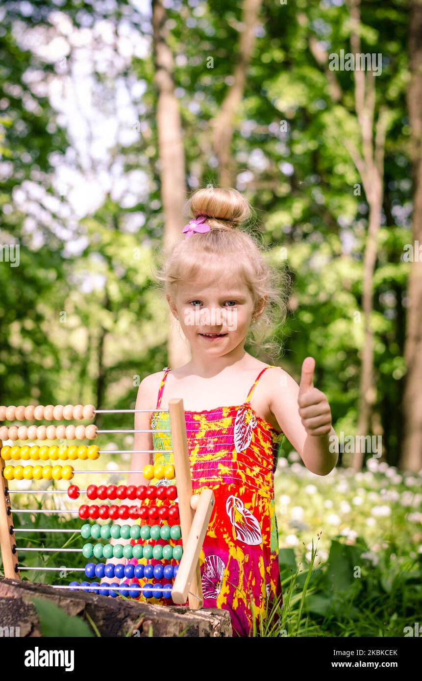 adorable blond girl learning maths in abacus in the spring forest Stock ...