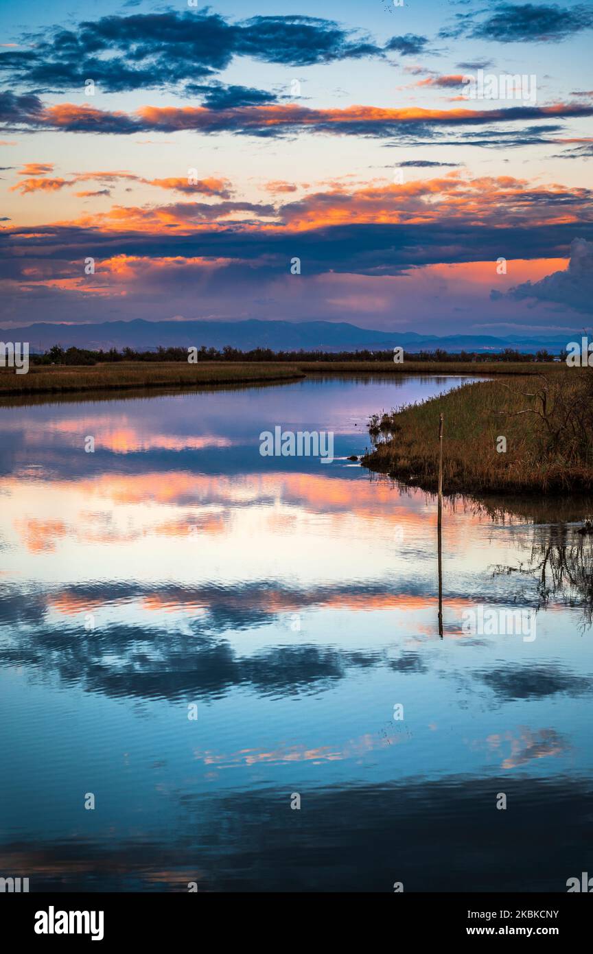 Towards the sunset. Marano lagoon late summer colors. Clouds and sun ...
