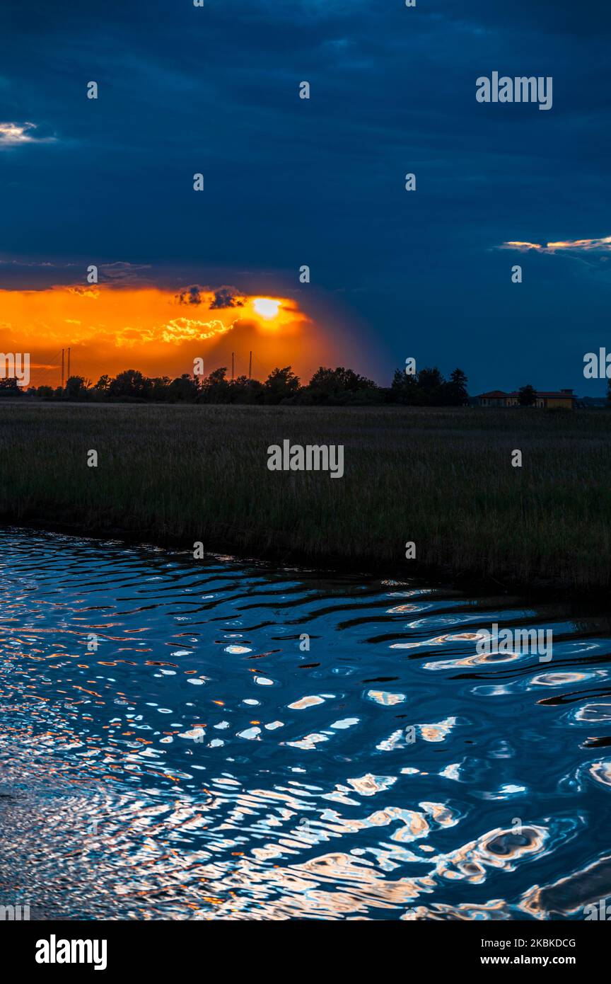Towards the sunset. Marano lagoon late summer colors. Clouds and sun ...