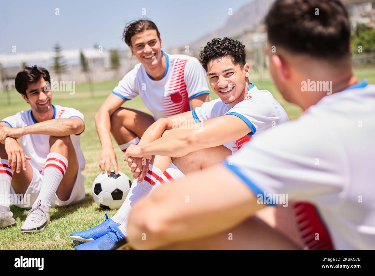 Soccer, relax and team on a football field talking, team building and ...