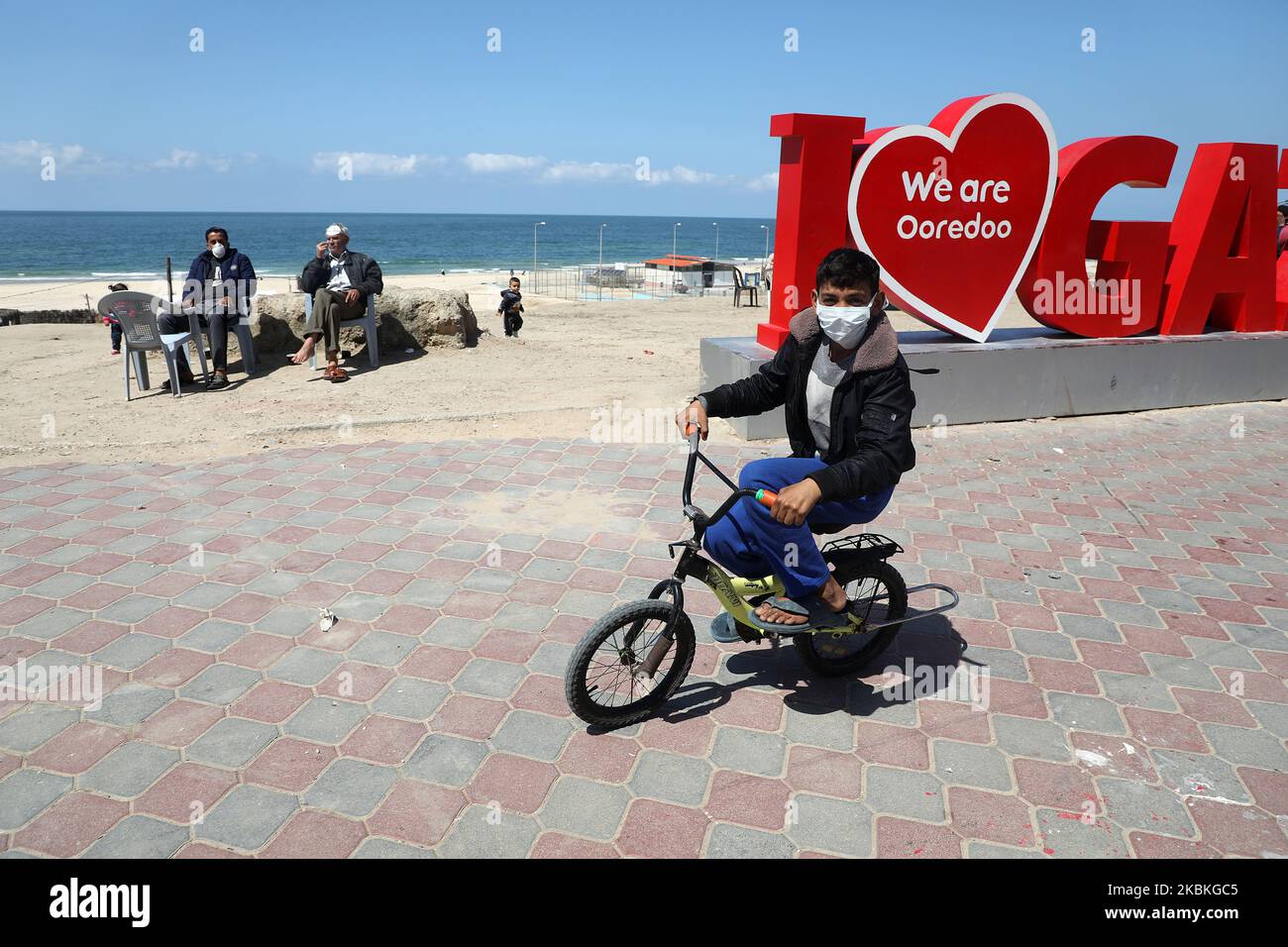 Palestinians wearing a protective face mask on the beach of Gaza city ...