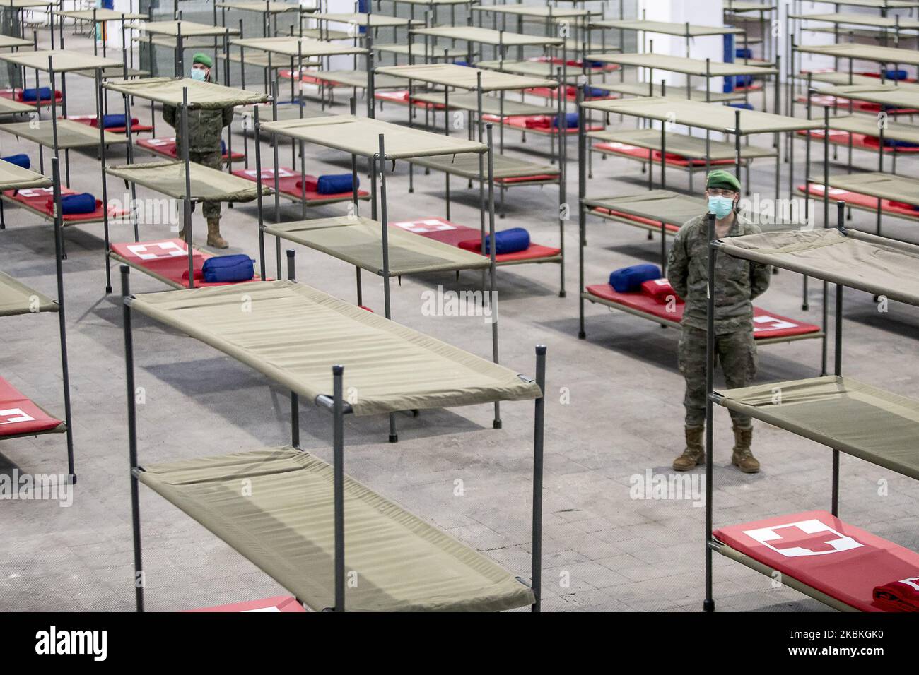 A Spanish soldier stands next to beds set up at a temporary hospital ...