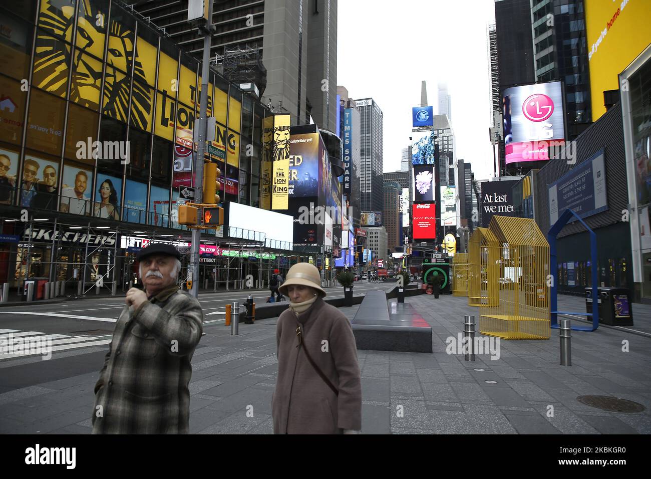 A couple walk through a mostly empty Times Square, New York, US, on ...