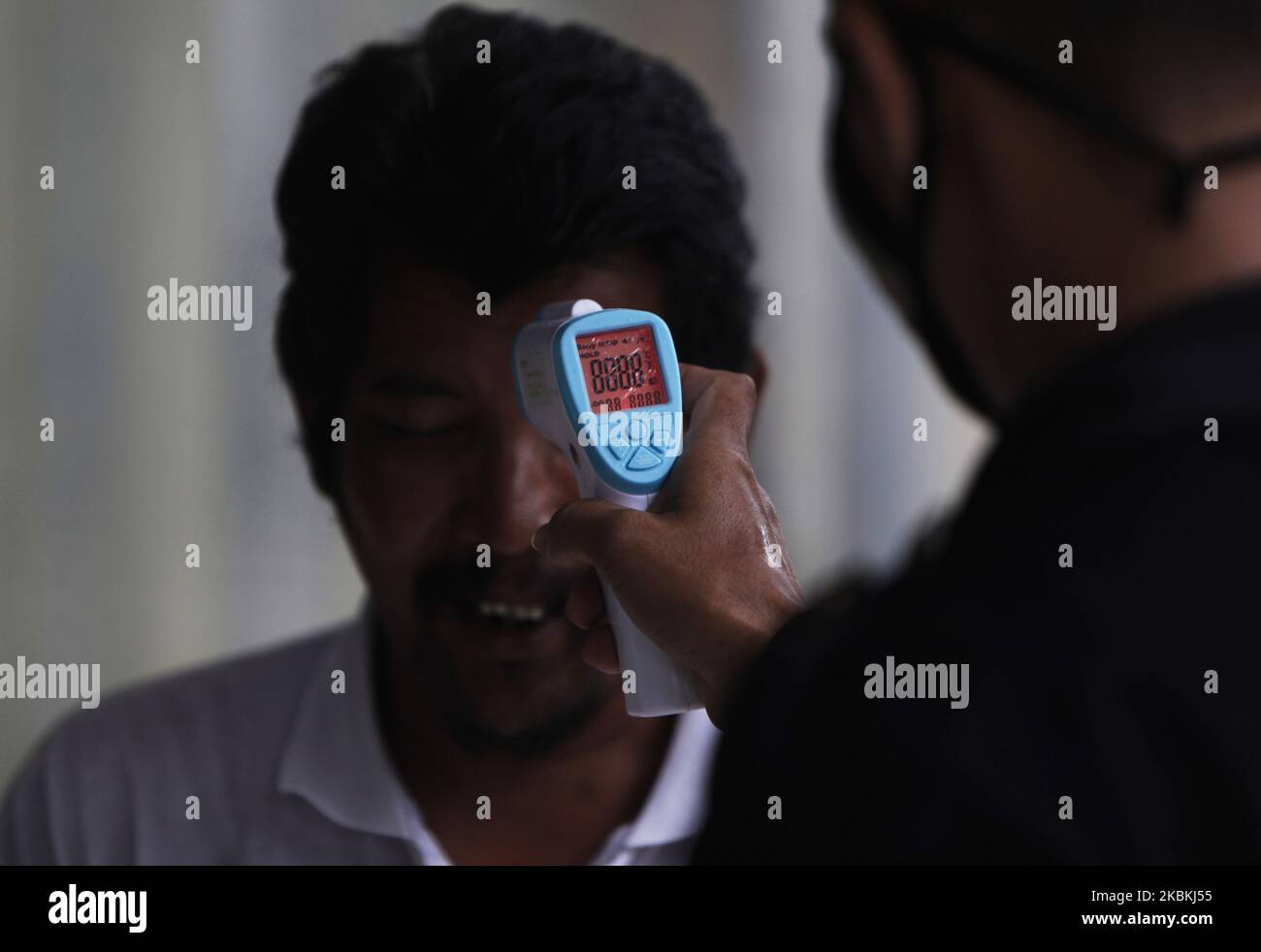 Security officers check the body temperature (thermal scanner) of ...