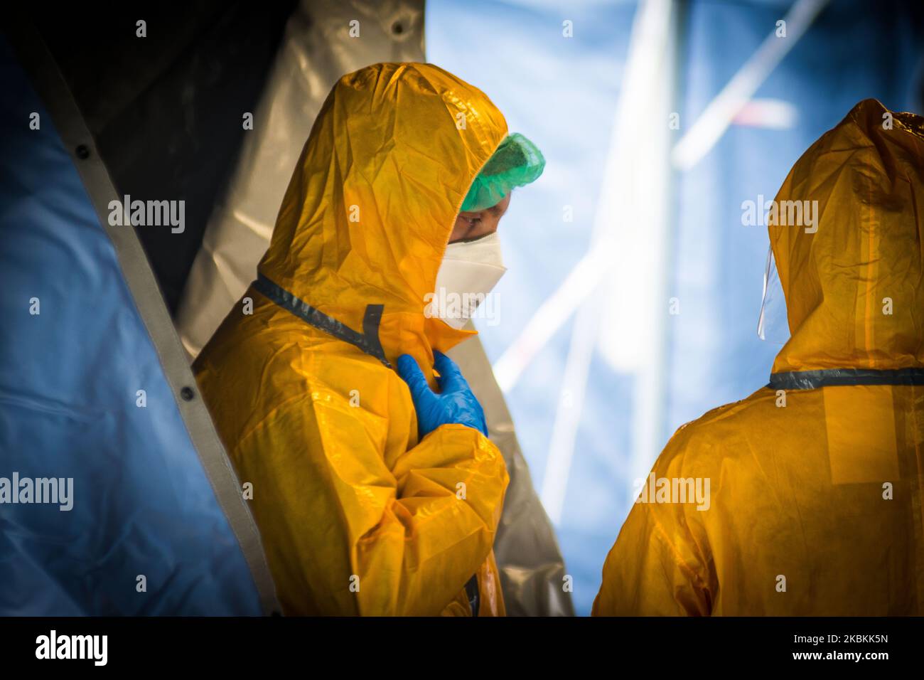 The hospital worker wearing a mask and protective equipment in a tent ...