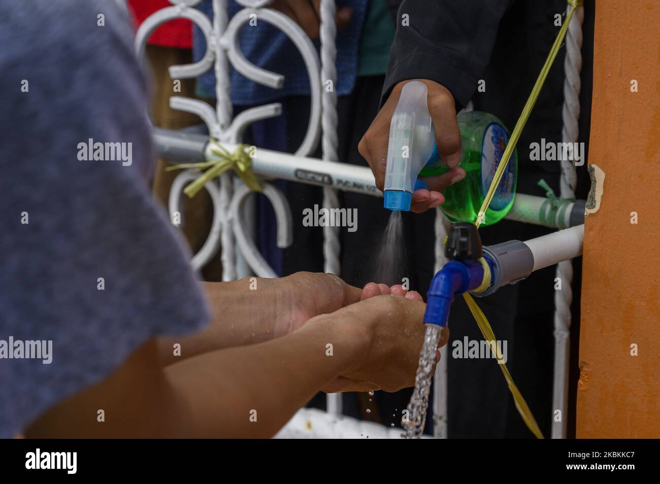 Muslims wash their hands before entering the mosque to perform Friday ...