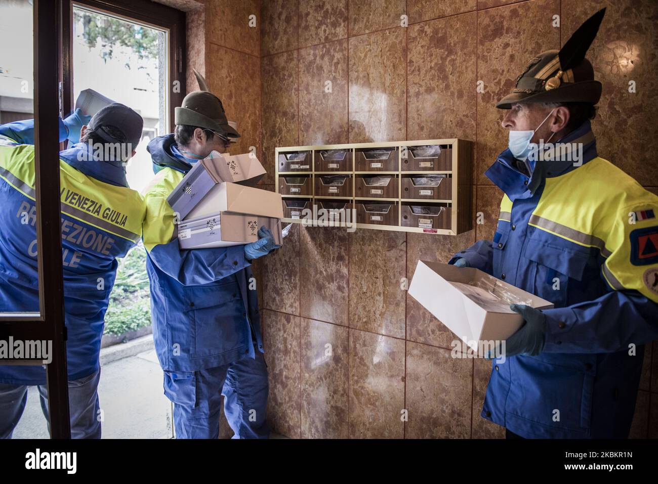 Volunteers of the Civil Protection corps (Protezione Civile) go door to ...