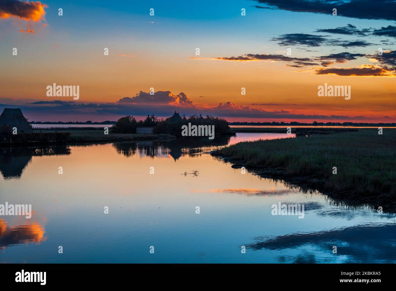 Towards the sunset. Marano lagoon late summer colors. Clouds and sun ...