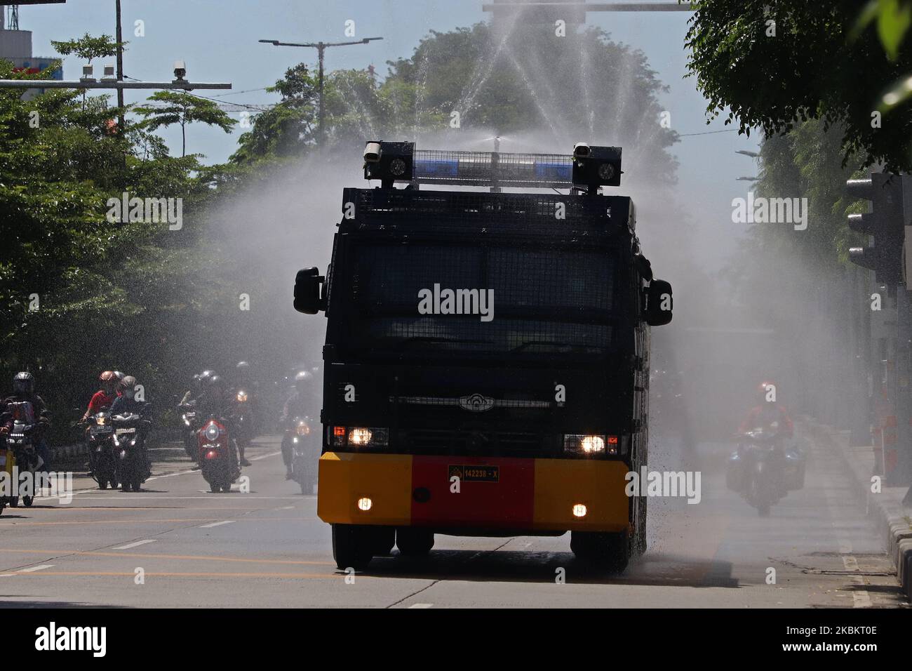 An Indonesian police riot control vehicle sprays disinfectant amid the ...