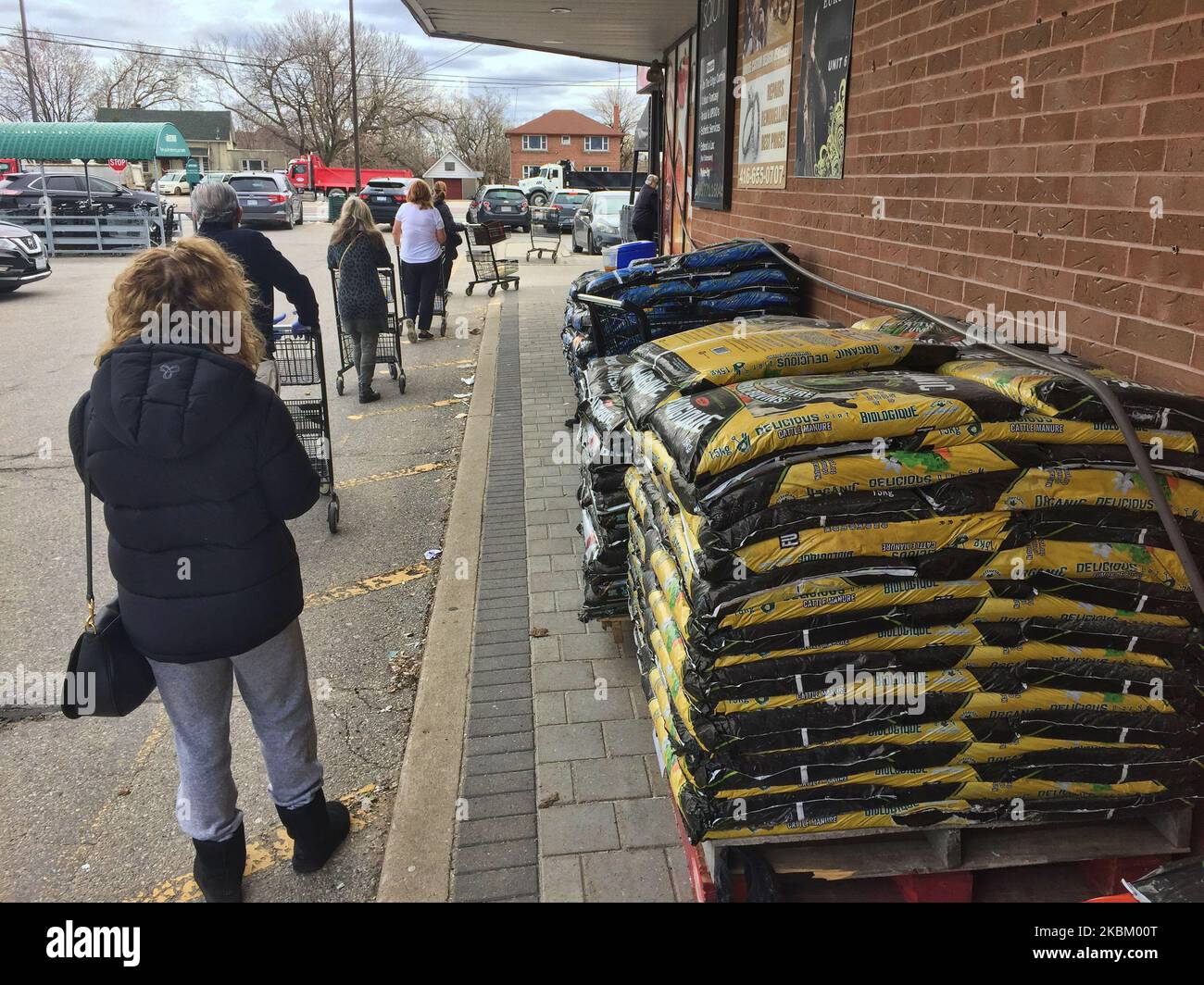 People practicing social distancing (physical distancing) as they wait ...