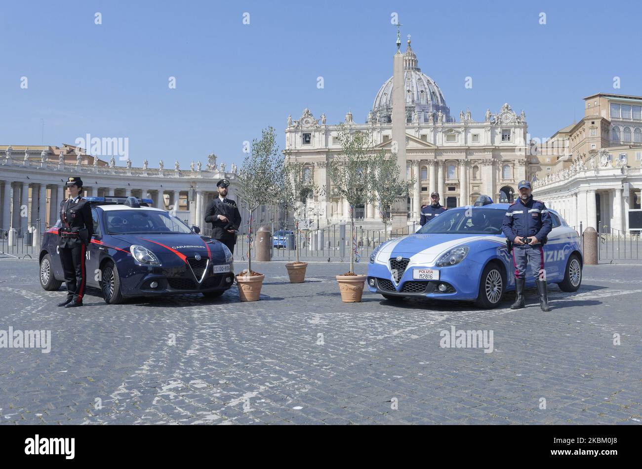 Small olive trees are placed next to the patrol of Italian police in St ...