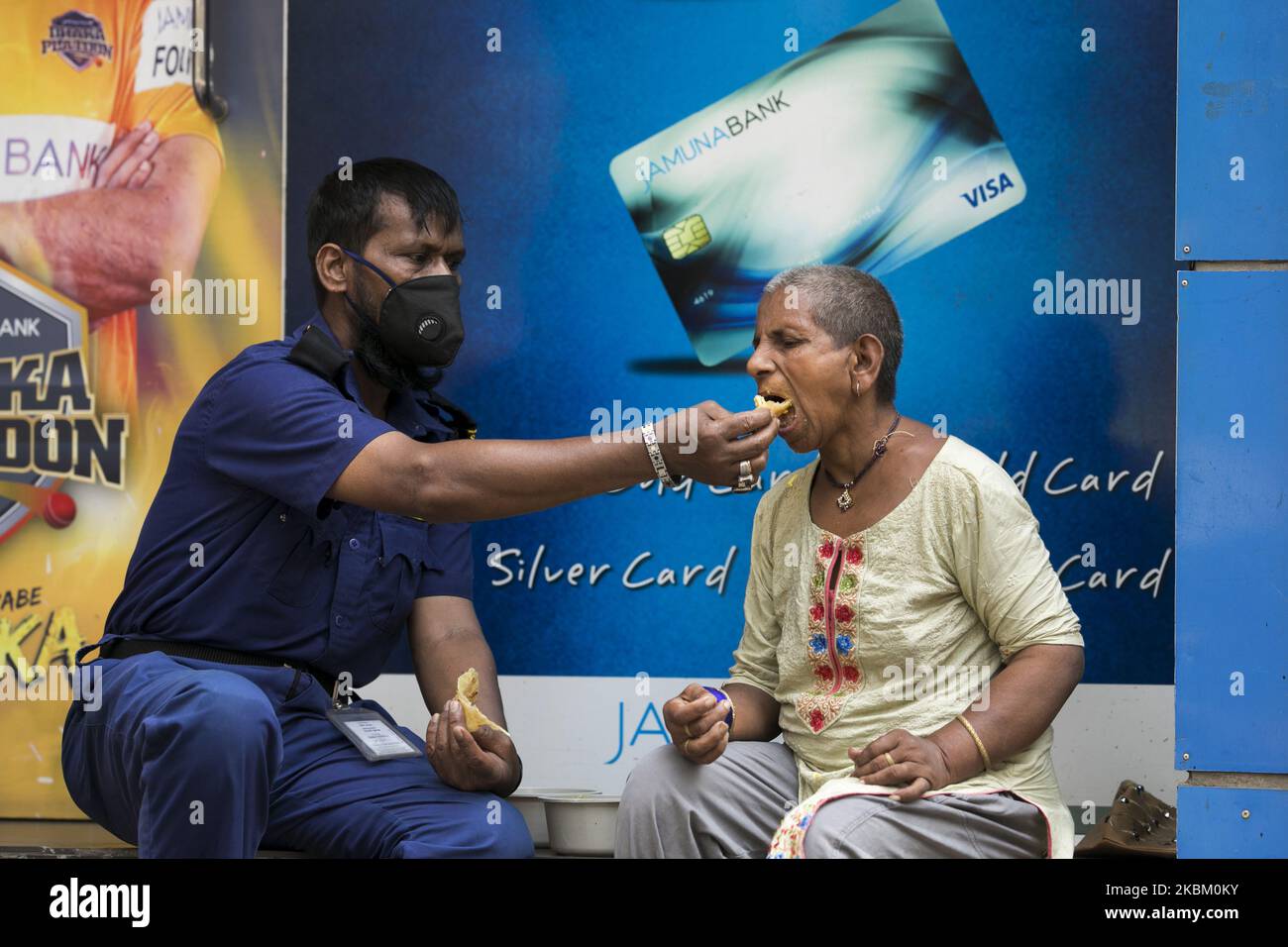 A security guard giving foods to his disable relatives in front of his ...
