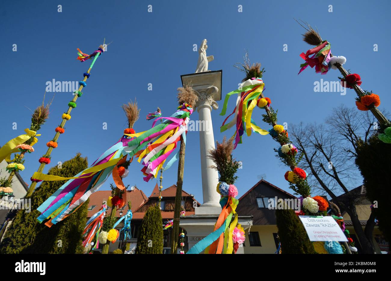 Colorful Easter palms exposed around the stone figure of St. Szymon ...