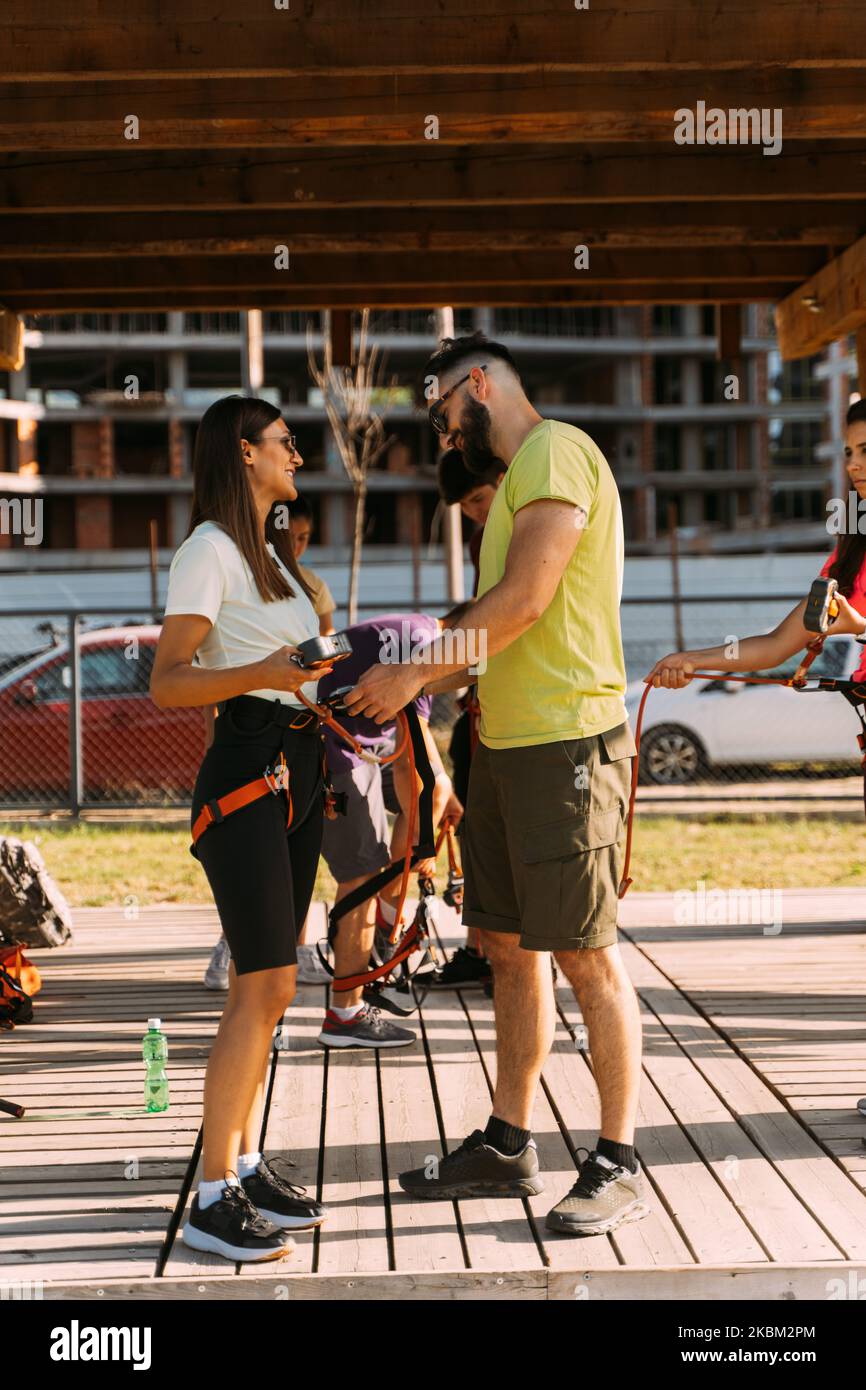 Handsome man putting the protectors on a pretty girl in the adventure ...