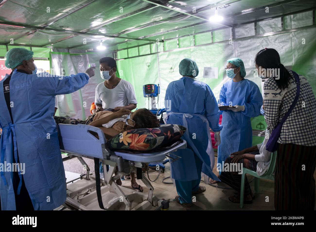A medical worker checks body temperature of a man at the entrance of ...