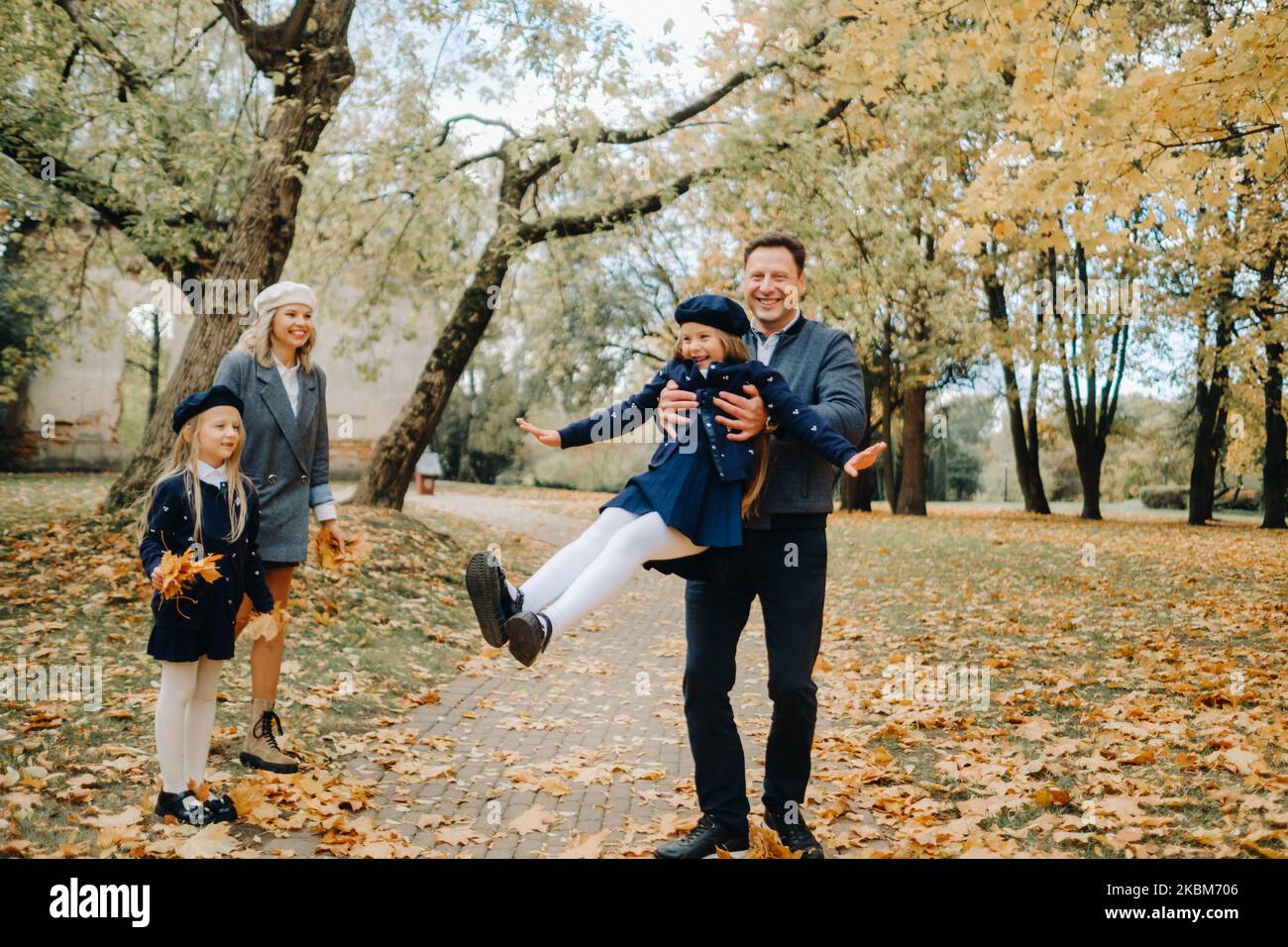 A large family walks in the park in the fall. Happy people in the ...