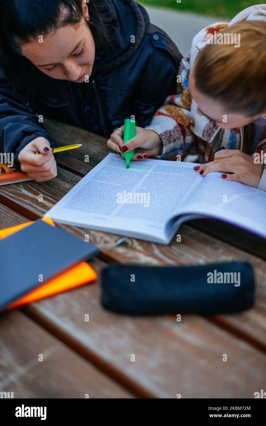 Two beautiful learners are underlining the most important parts before ...