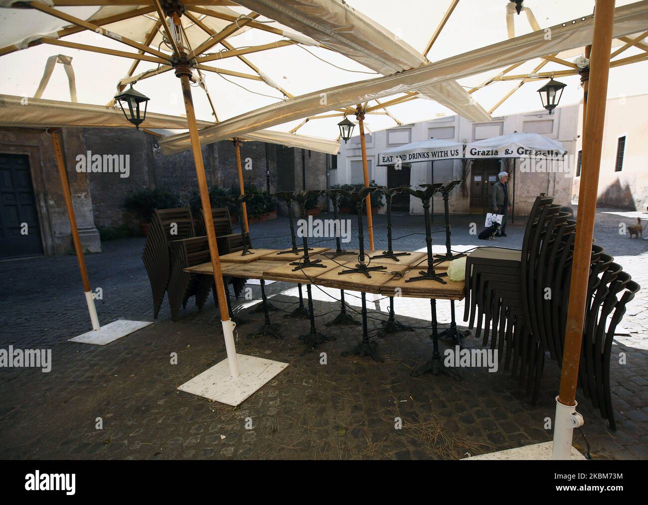 Chairs and tables under the umbreallas of a closed restaurant in the ...