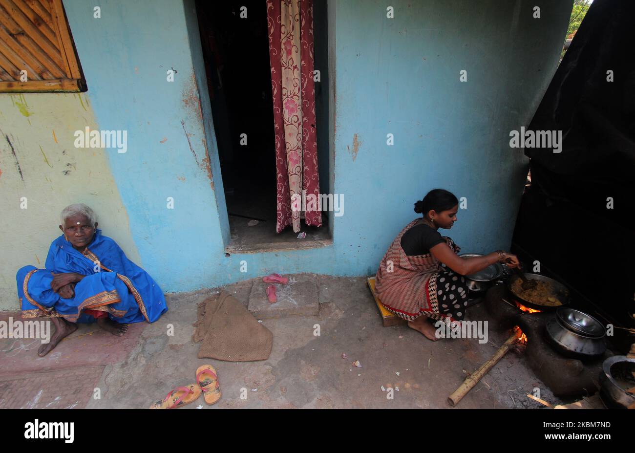 Slum dwellers are seen at their living slum as they are busy in their ...