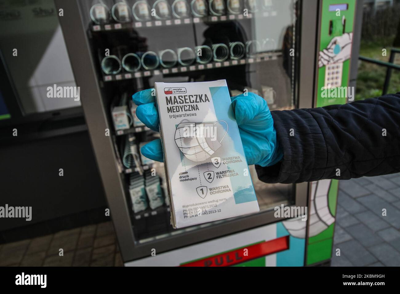 Woman buying face mask from the vending machine is seen in Warsaw ...