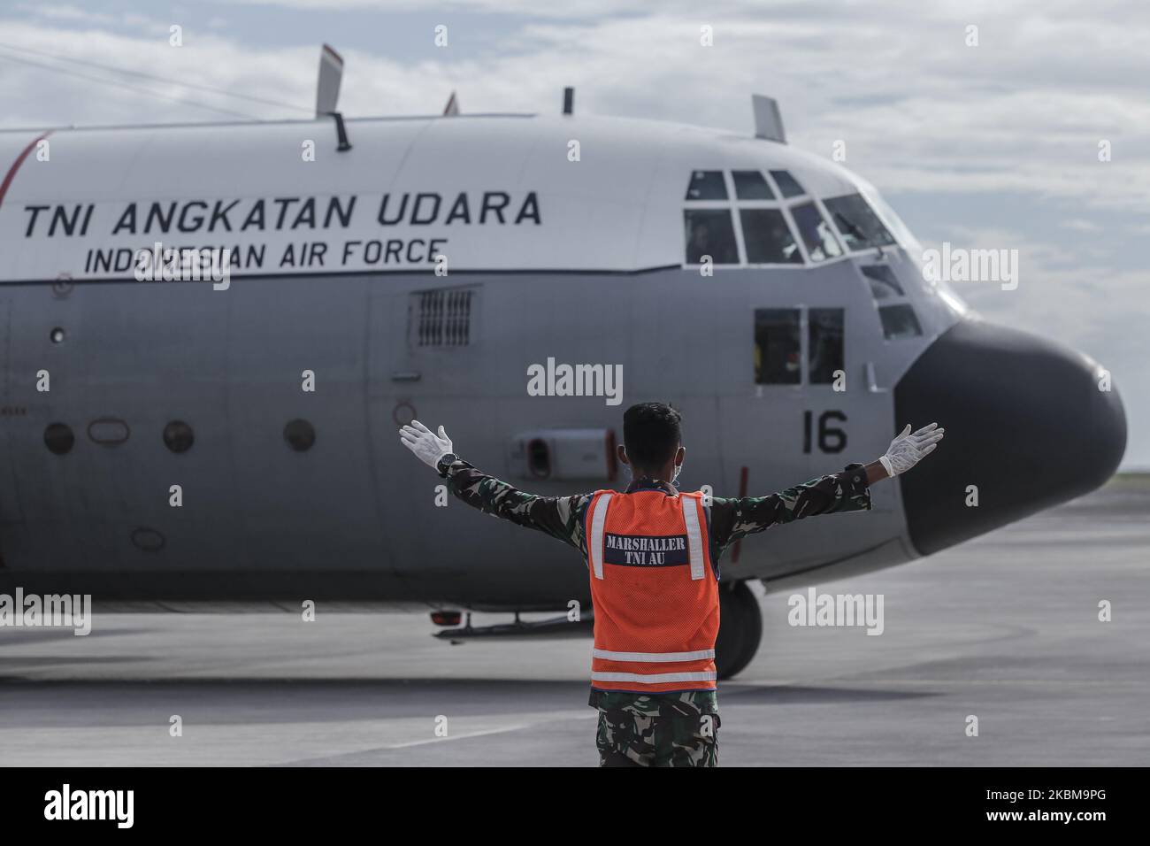 Indonesian army wearing gloves guide military cargo aircraft carrying ...