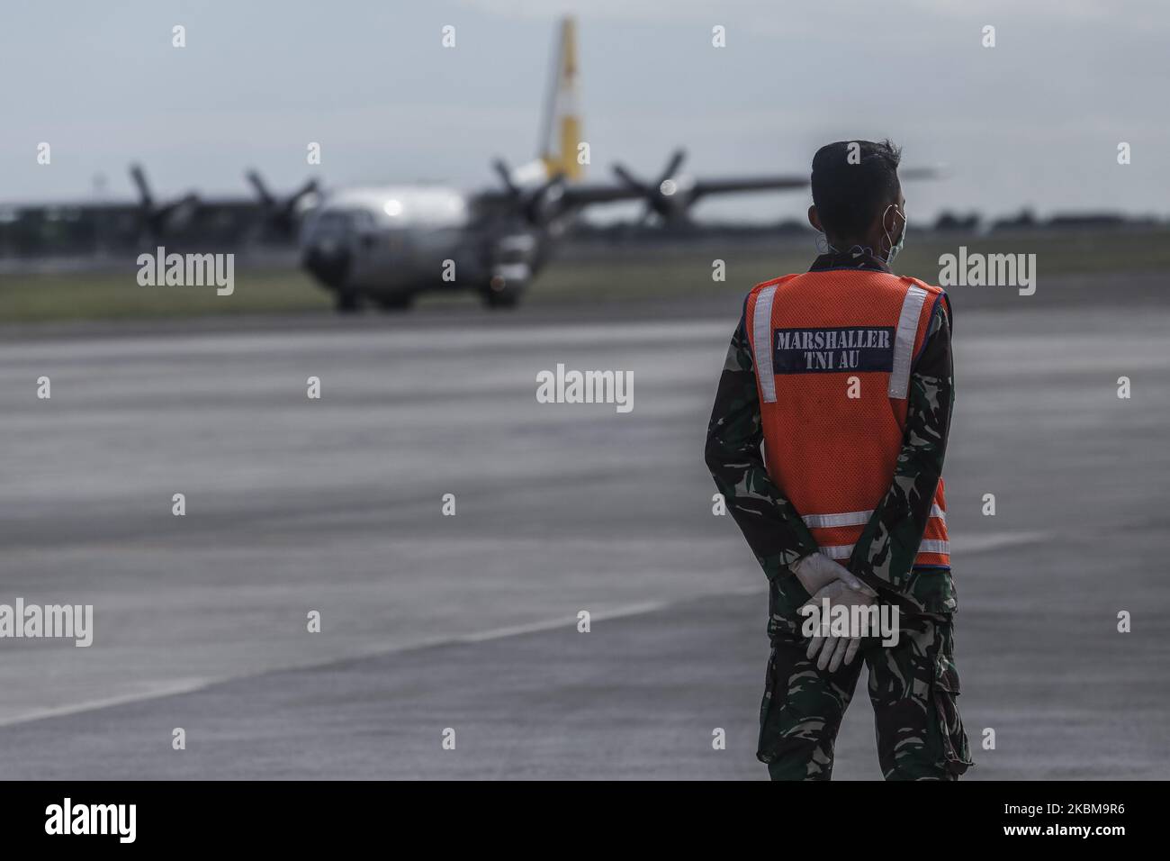 Indonesian army wearing gloves waits military cargo aircraft carrying ...