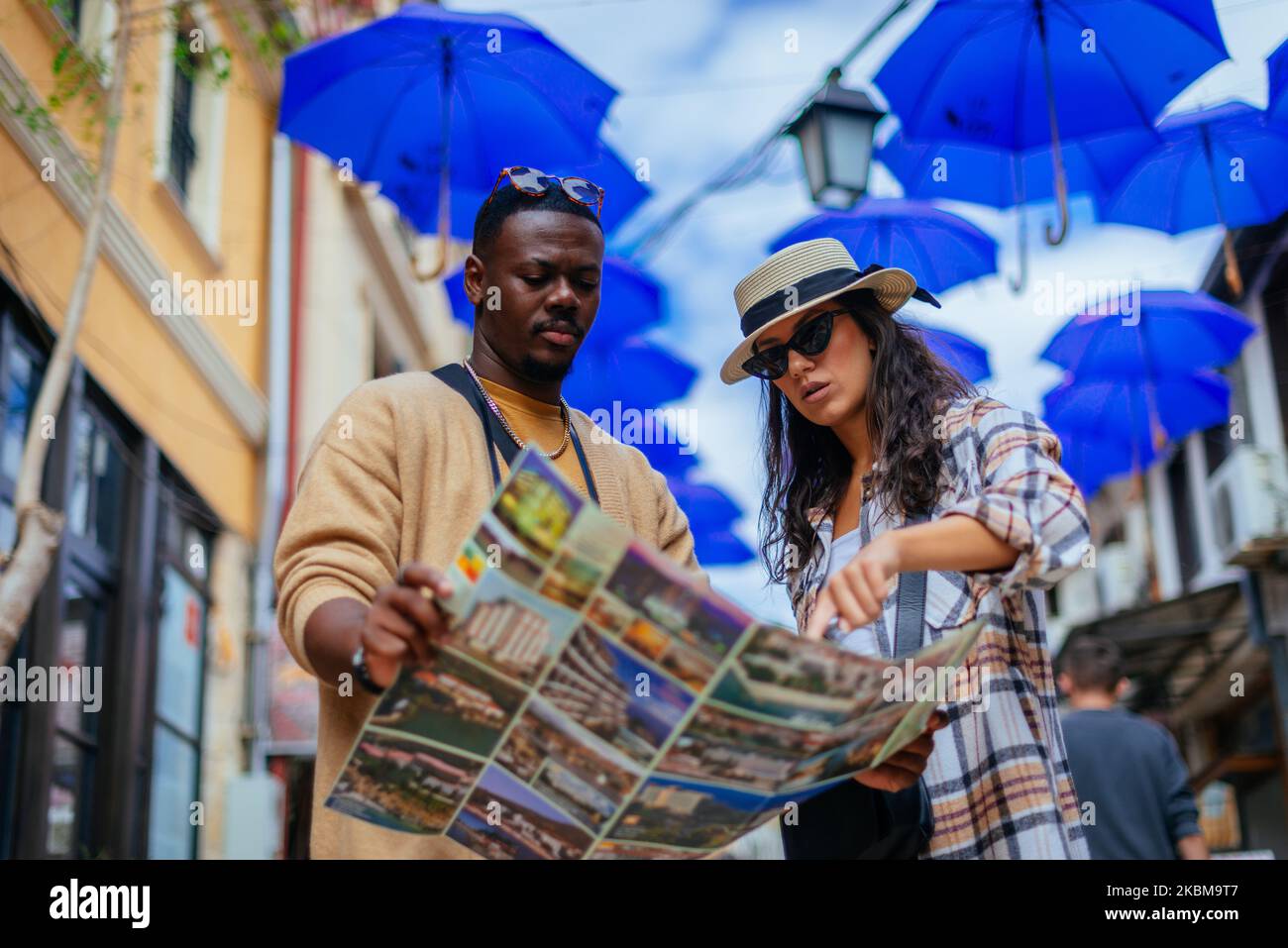 A young multiracial couple is looking at the map for a new place to ...