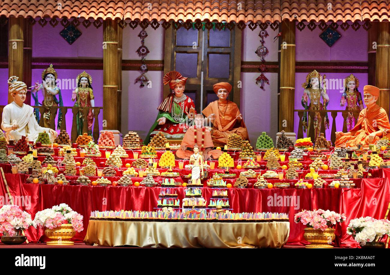 Mountains of sweets and vegetarian snacks are displayed in front of the ...