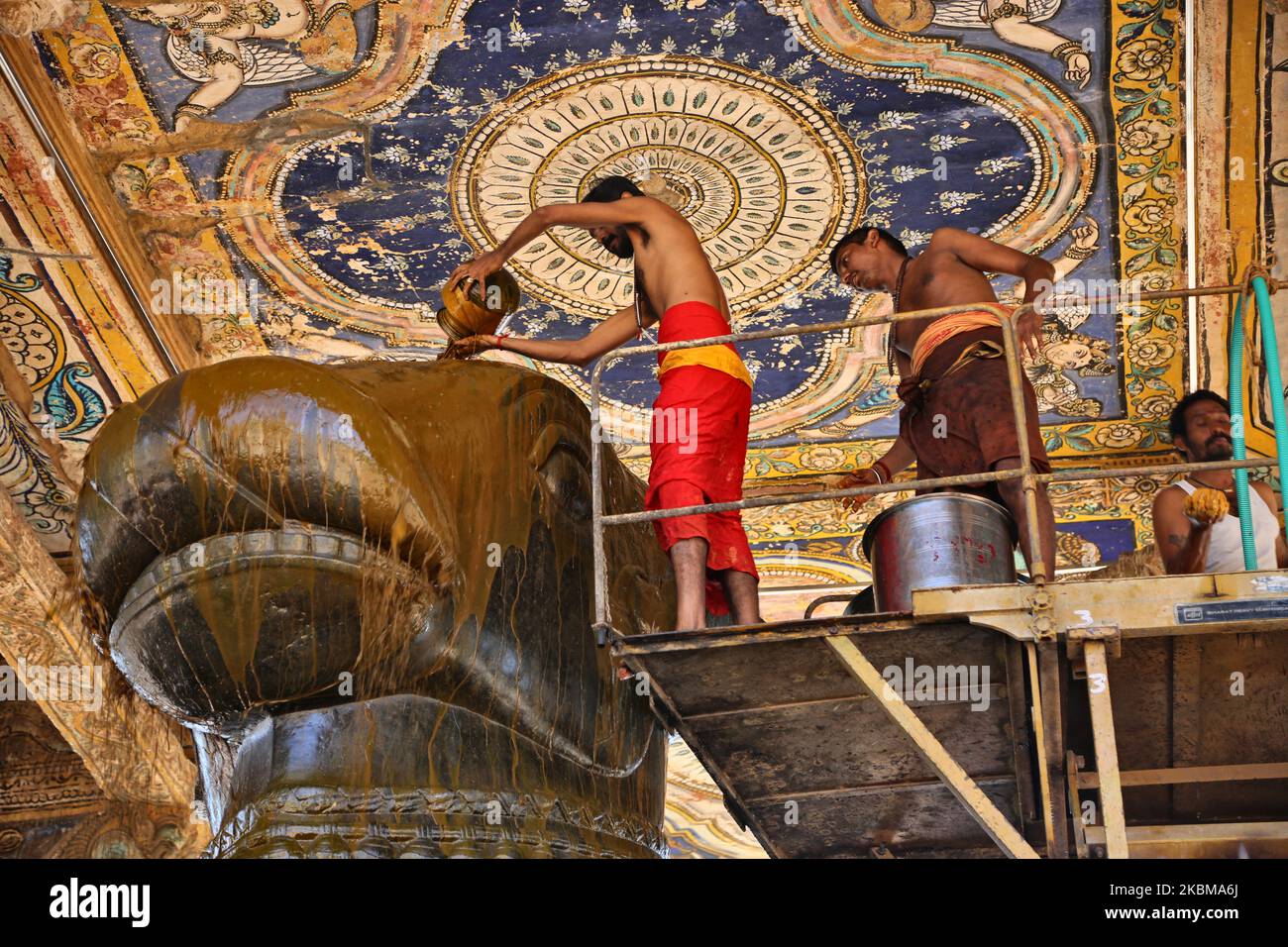 Tamil Hindu priests perform special prays as they bathe a large stone ...